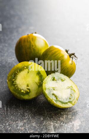 Green zebra tomatoes on black table Stock Photo - Alamy