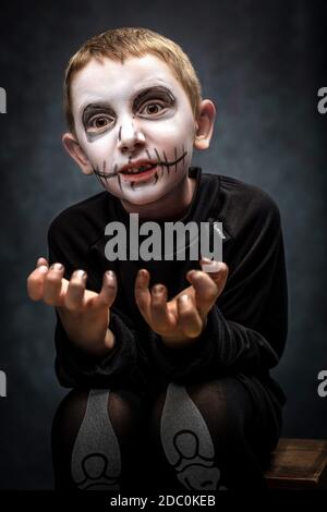child dressed as skeleton in scary pose. halloween costume, studio shot ...