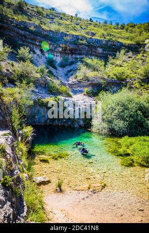 Divers in Pozo Azul. Underwater Speleology. Pozo Azul is a spring or ...