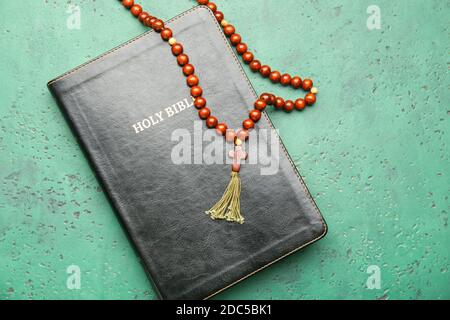 Hole Bible and rosary beads on color background Stock Photo - Alamy