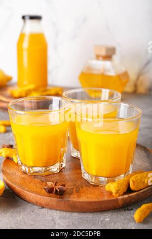 Glasses of healthy turmeric drink on white background Stock Photo - Alamy