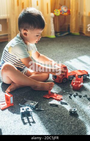 adorable preschooler boy playing with colorful building blocks at home ...