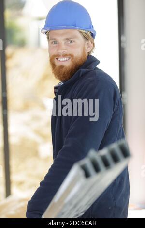 workman carrying a metal frame Stock Photo - Alamy