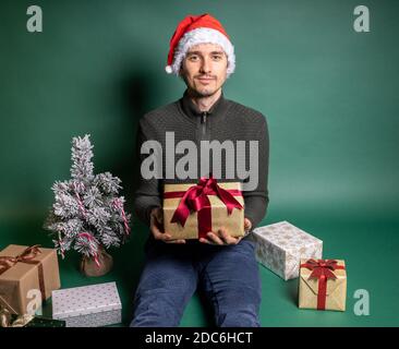 man with many wrapped gifts on green background Stock Photo - Alamy