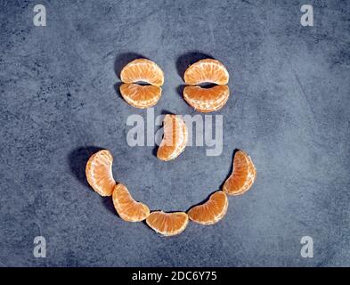 A high angle shot of tangerine pieces and seeds shaped like a smiley ...