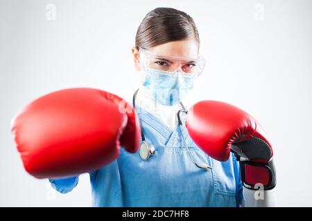 Female doctor wearing red boxing gloves celebrating with arms raised ...