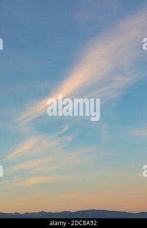 Complementary colors of orange cirrus clouds with blue sky and water at ...