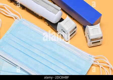 Two lorry toys, and face mask in concept about transport departament ...