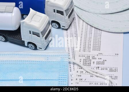 Two lorry toys, and face mask in concept about transport departament ...