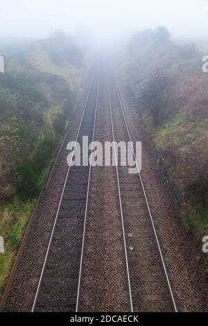 A railway line disappearing into the mist Stock Photo - Alamy