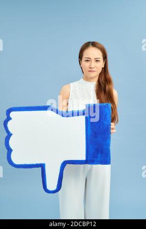 Young woman holding a dislike icon over color background Stock Photo ...