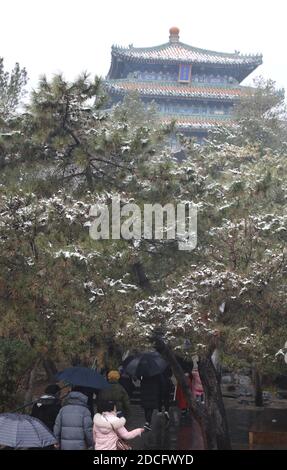 Beijing, China. 21st Nov, 2020. A woman walks on a street in snow in ...