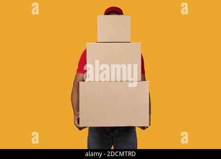 Black delivery man holding pile of boxes Stock Photo - Alamy