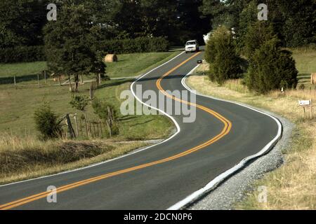 A 2 lane paved country road with double yellow lines and trees on Stock ...