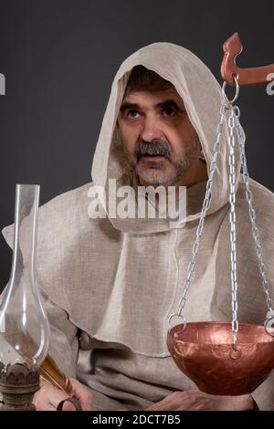 A monk alchemist is engaged in science, studying ancient manuscripts on ...