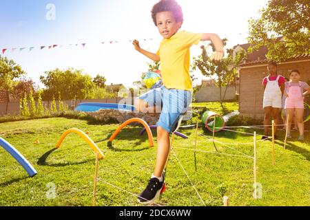 Race game with obstacles boys jump over barrier Stock Photo - Alamy