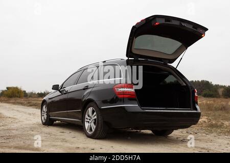 black car with open trunk near shopping trolley with grocery Stock ...