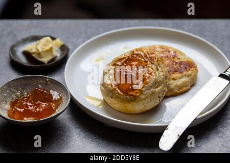 Home made crumpets with butter and orange jam Stock Photo - Alamy