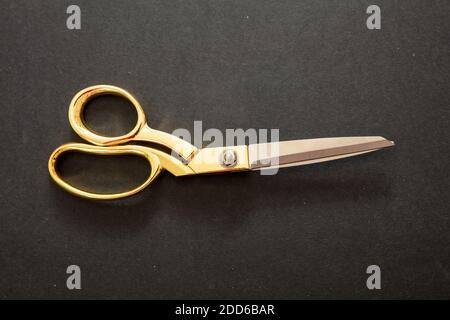Scissors golden silver color handle isolated on black background ...