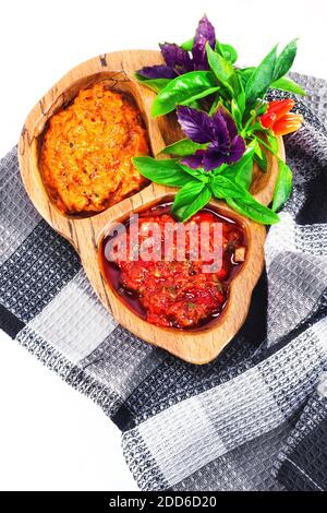 Balkan meze consisting of two types of red pepper spread, bread ...
