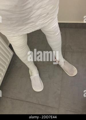 Man with foot wrapped in medical bandage on white background, closeup ...
