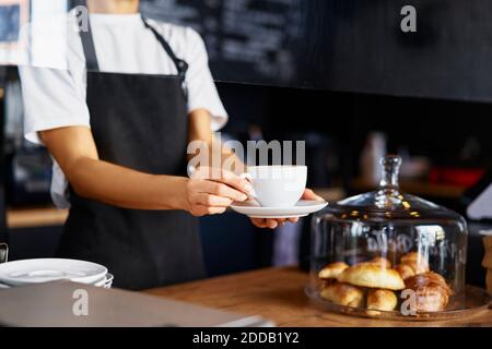 Midsection of waitress giving coffee at cafe Stock Photo - Alamy