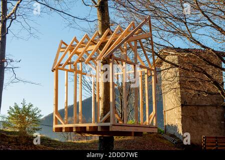 The frame of an unfinished wooden house on a mountain slope, amidst ...