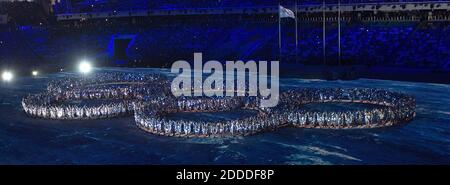 Performers dressed in mirrored costumes form the Olympic Rings, during ...