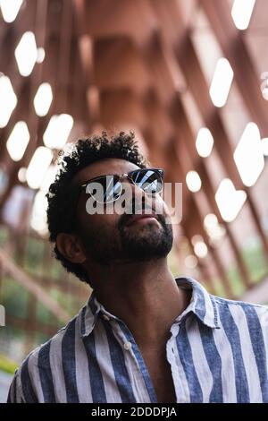 Hispanic man with beard wearing casual red t shirt showing and pointing ...