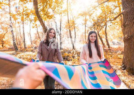 family laying down picnic blanket in summer park Stock Photo - Alamy