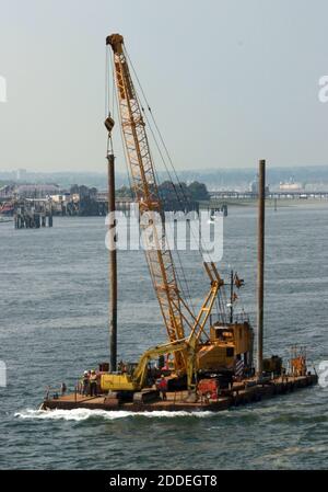 Crane on a floating pontoon in Portsmouth harbour. Performing dredging ...