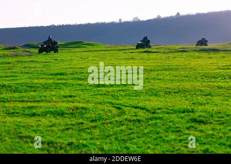 ATVs ride on green field. Clip. Top view of beautiful green field and ...