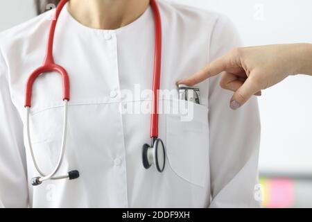 Banknote is thrust into doctor's pocket closeup Stock Photo - Alamy