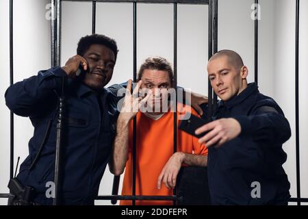 A prisoner with tattoos on his face takes a selfie with his fellow ...