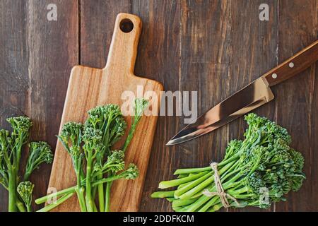 Bunch of broccolini on wooden table. Angle view with copy space Stock ...