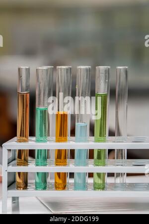 Image of test tubes with colorful solutions are placed in a rack in a ...