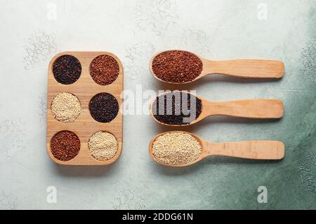 Composition with different types of quinoa on black background, top ...