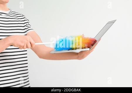 Man cleaning laptop on light background Stock Photo - Alamy