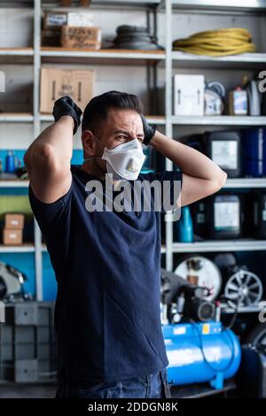 Male worker in face mask with checklist collecting order at hardware ...
