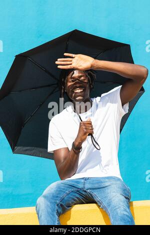 Cheerful Black Hipster Guy Covering Face With Smartphone With Blank ...