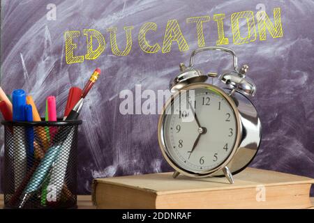 Science and education - alarm clock and high pile group of red books on ...