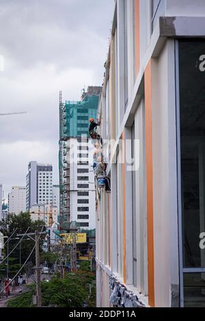 Painter painters suspended on ropes with abseil climbing harness ...