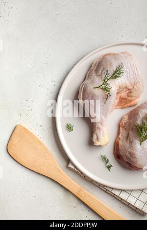 Farmed poultry. Chilled raw chicken legs on a plate with vegetables and ...