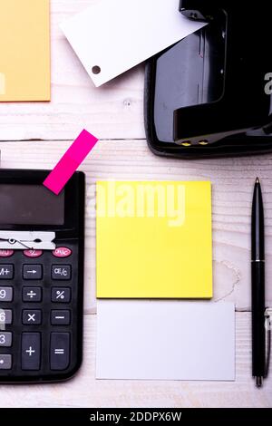 Hole punch near pen on white wooden background Stock Photo - Alamy