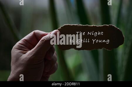 Hands holding torn paper with motivational quote and blurred dark ...