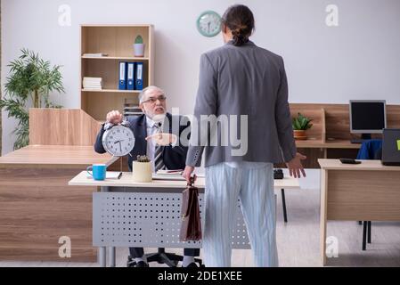 Businessman scolding employee for being late in office Stock Photo - Alamy
