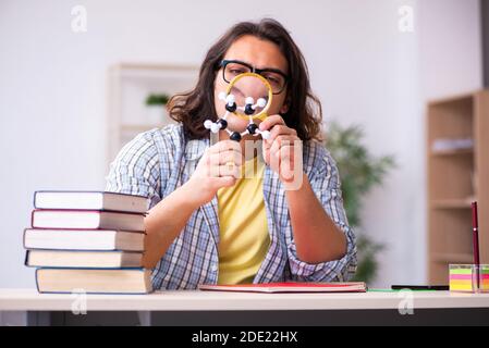 Male student with book and molecular model in library Stock Photo - Alamy