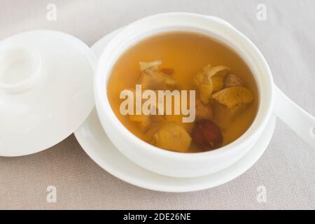an appetizer of Double-boiled Conch and Red Date Soup served in a white ...