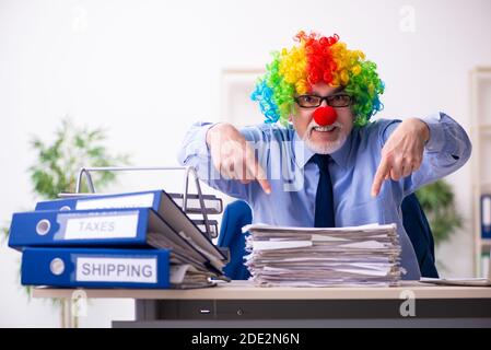 Aged businessman clown working in the office Stock Photo - Alamy