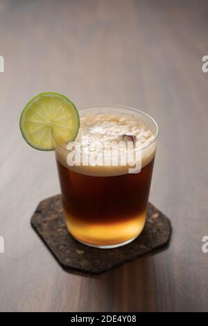 Espresso tonic in simple glass on walnut wood table with copy space ...